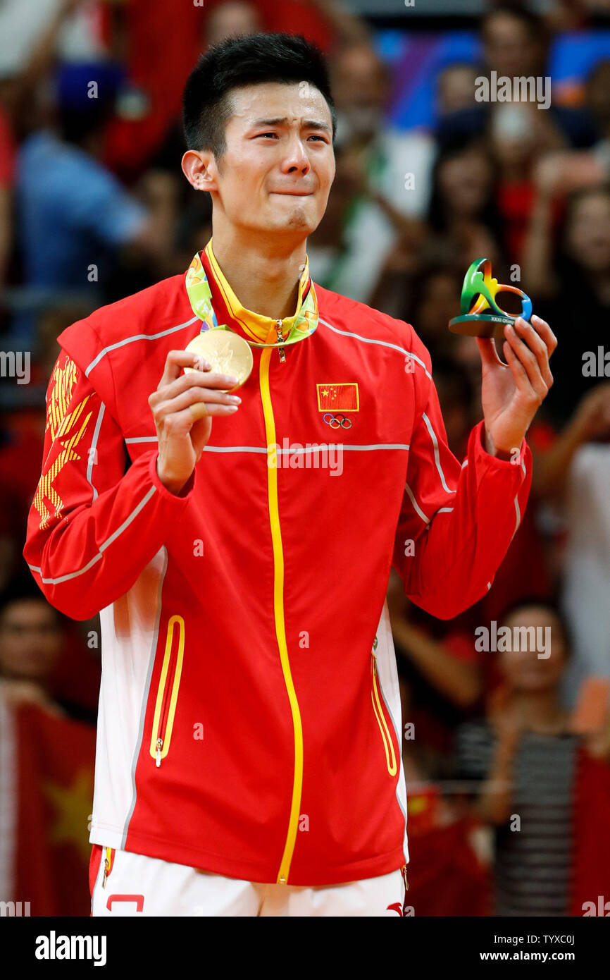 China's Long Chen holds up his gold medal after defeating Malaysia's ...