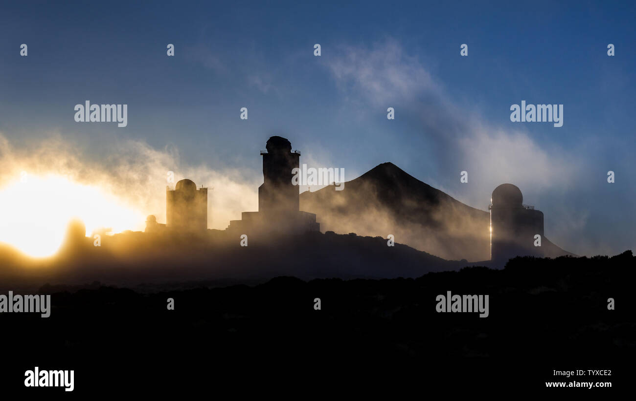 Sunset with fog and clouds around astronomical telescopes. Mount Teide ...