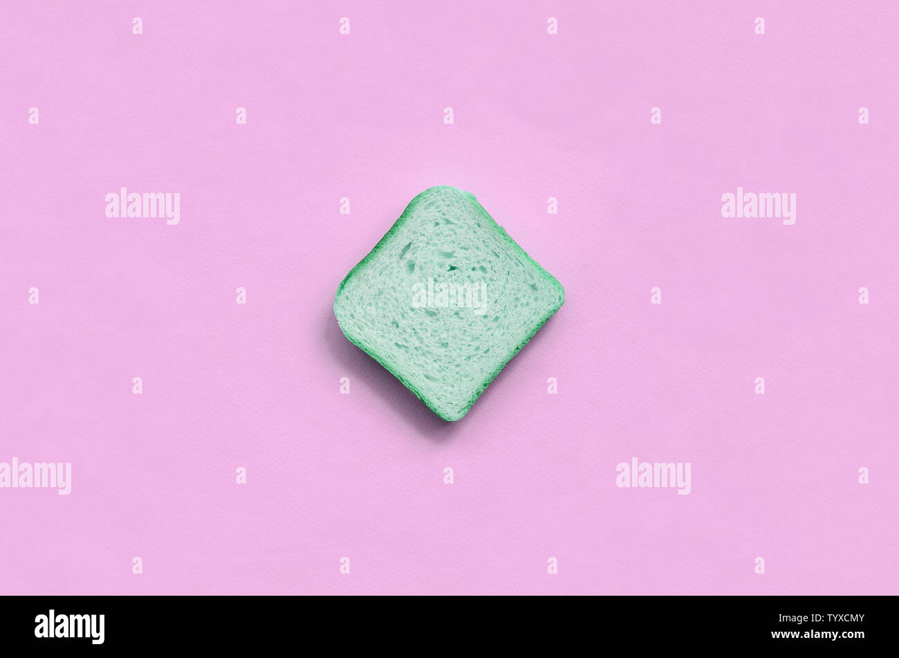 A piece of green bread lies on texture background of fashion pastel ...