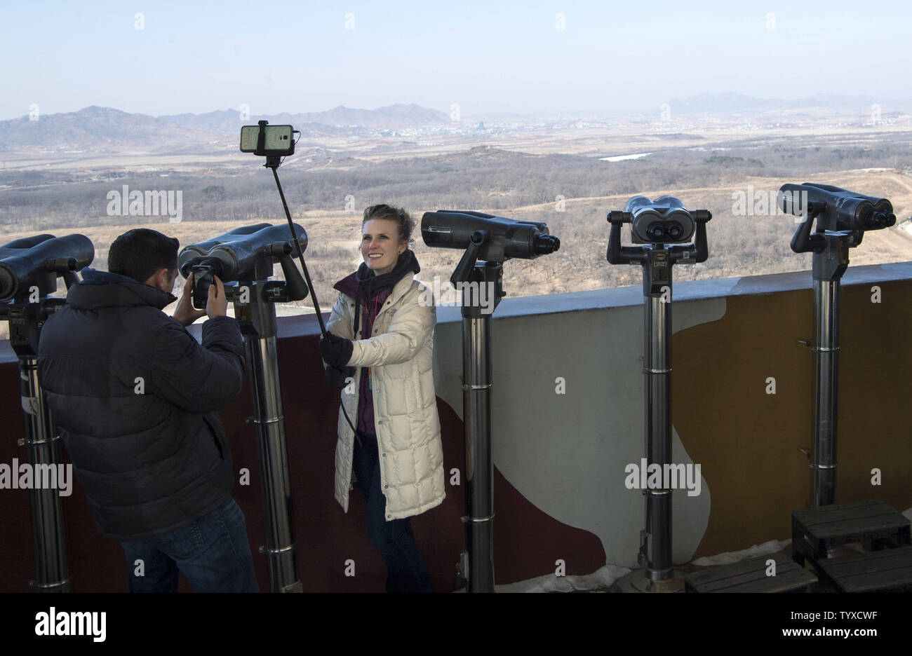 A tourist takes a selfie photograph looking over to the North Korean ...