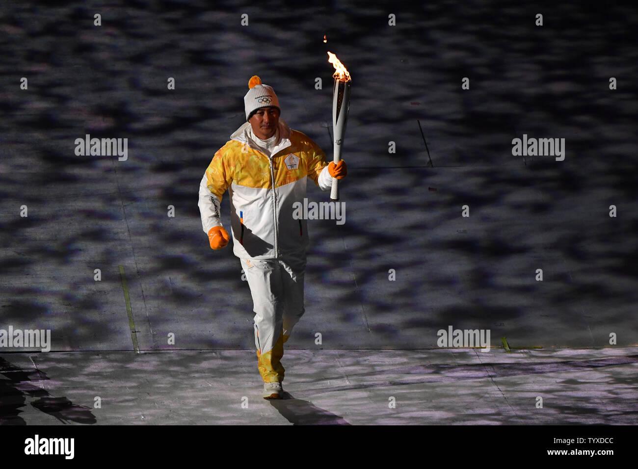 The Olympic torch is carried into the stadium during the opening ...