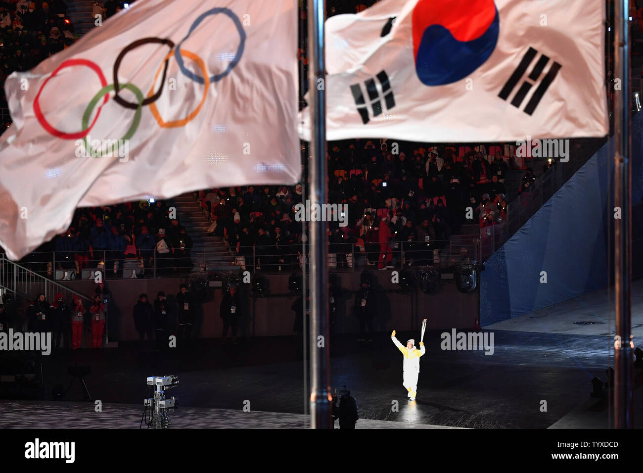 The Olympic torch is carried into the stadium during the opening ...