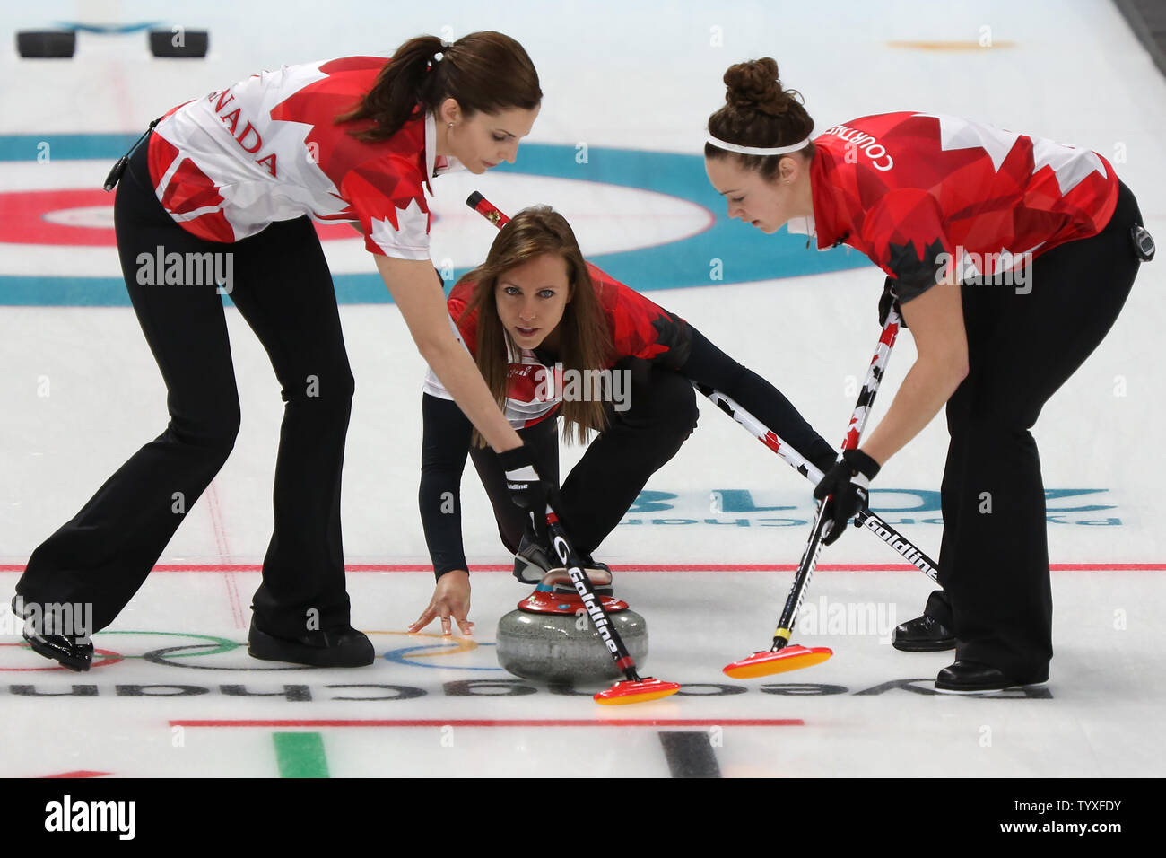 Rachel Homan of Canada delivers a stone as teammates Lisa Weagle (L ...