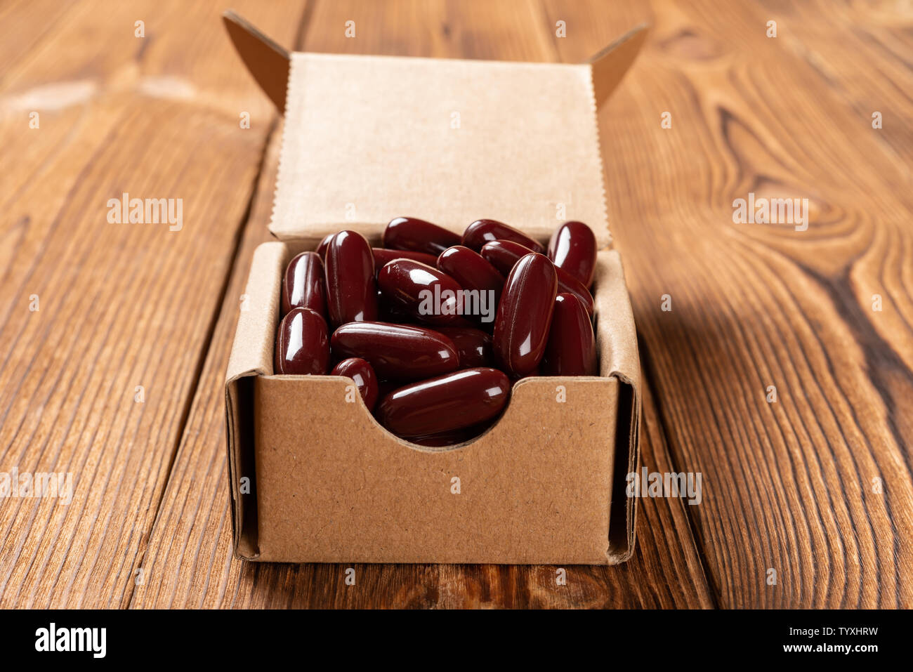 box of capsules on a wood table Stock Photo - Alamy