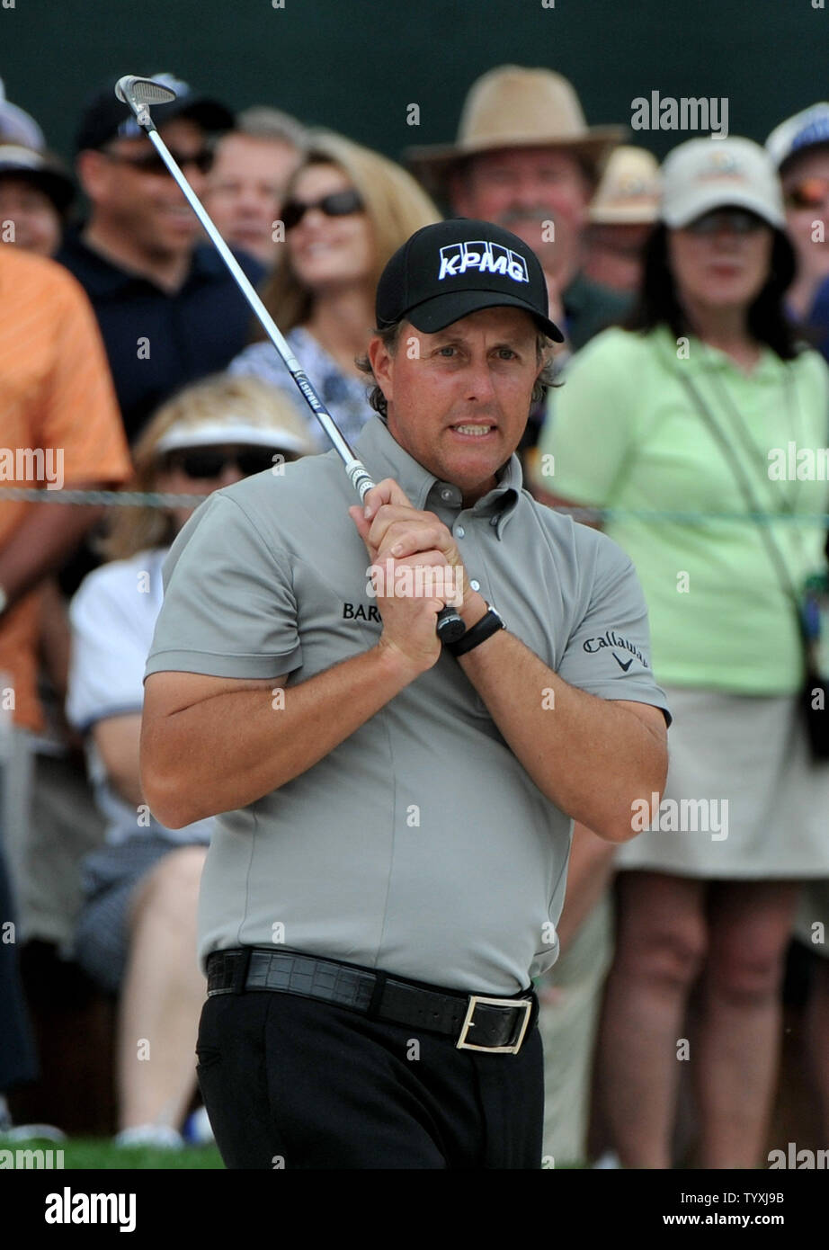 Phil Mickelson reacts after hitting out of a bunker on the ninth green ...