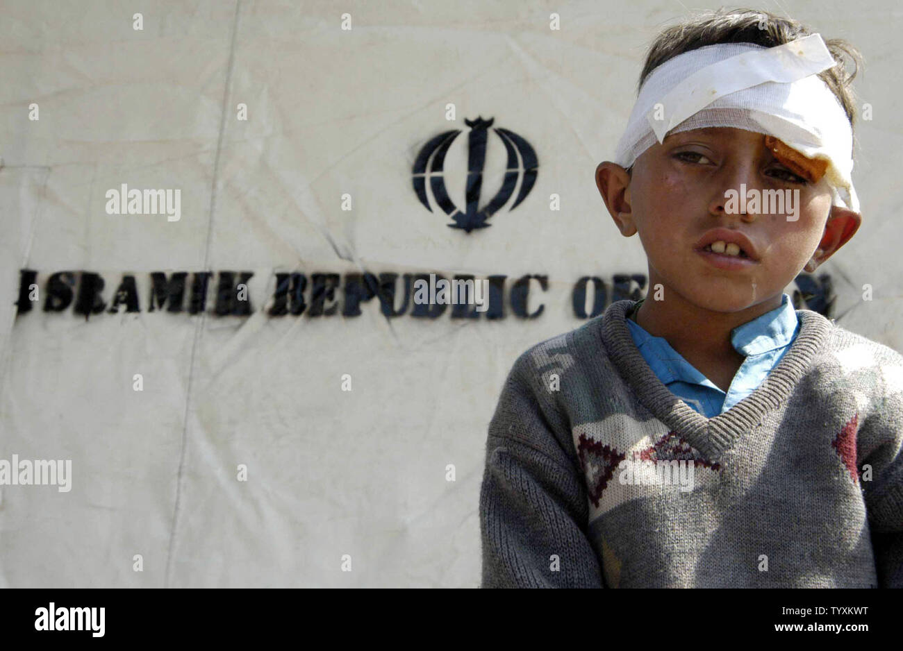 A Pakistani boy waits in front of an Iranian relief camp after an ...