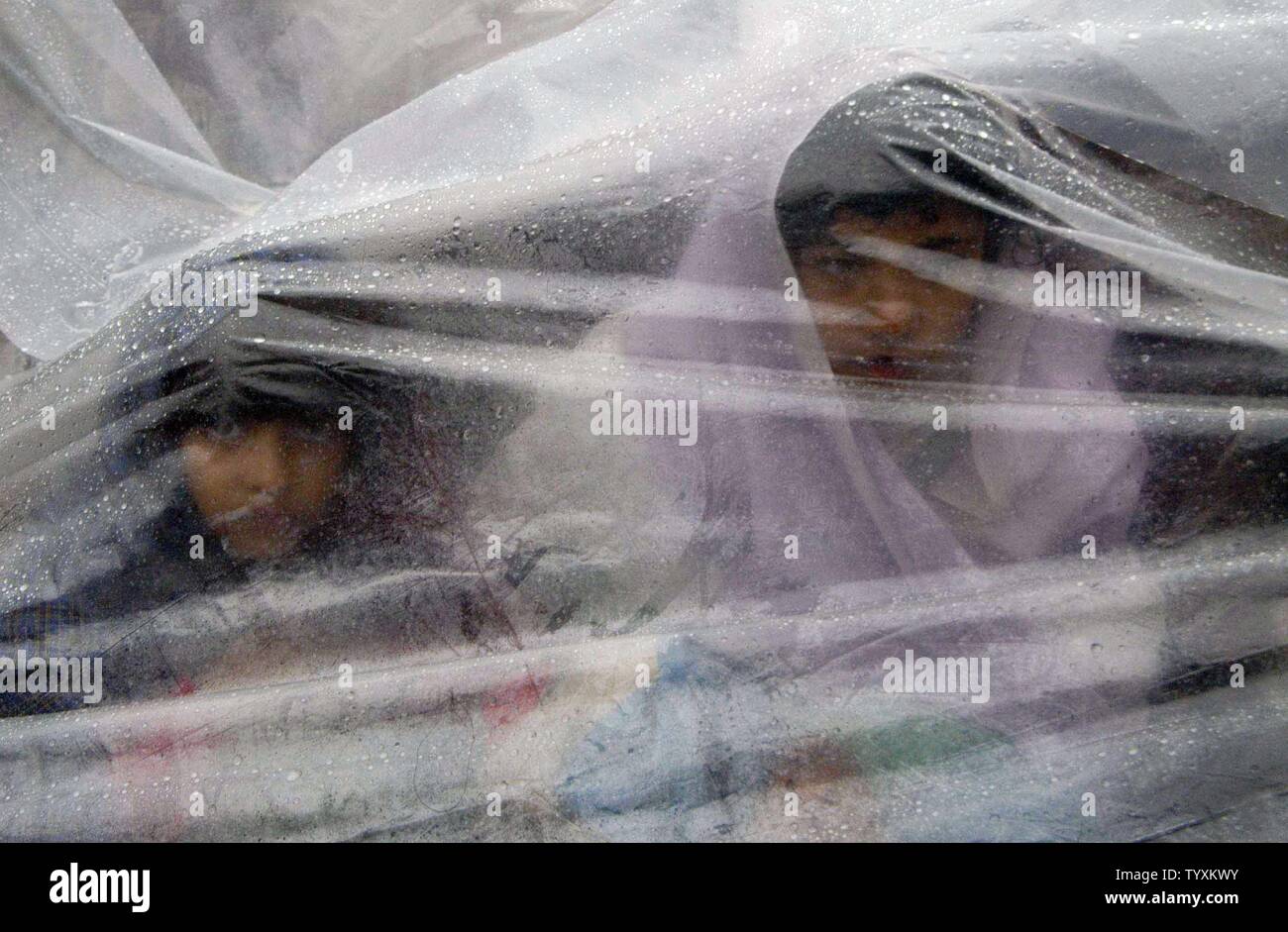 Two Pakistani boys take shelter from the rain in Balakot, Pakistan on ...