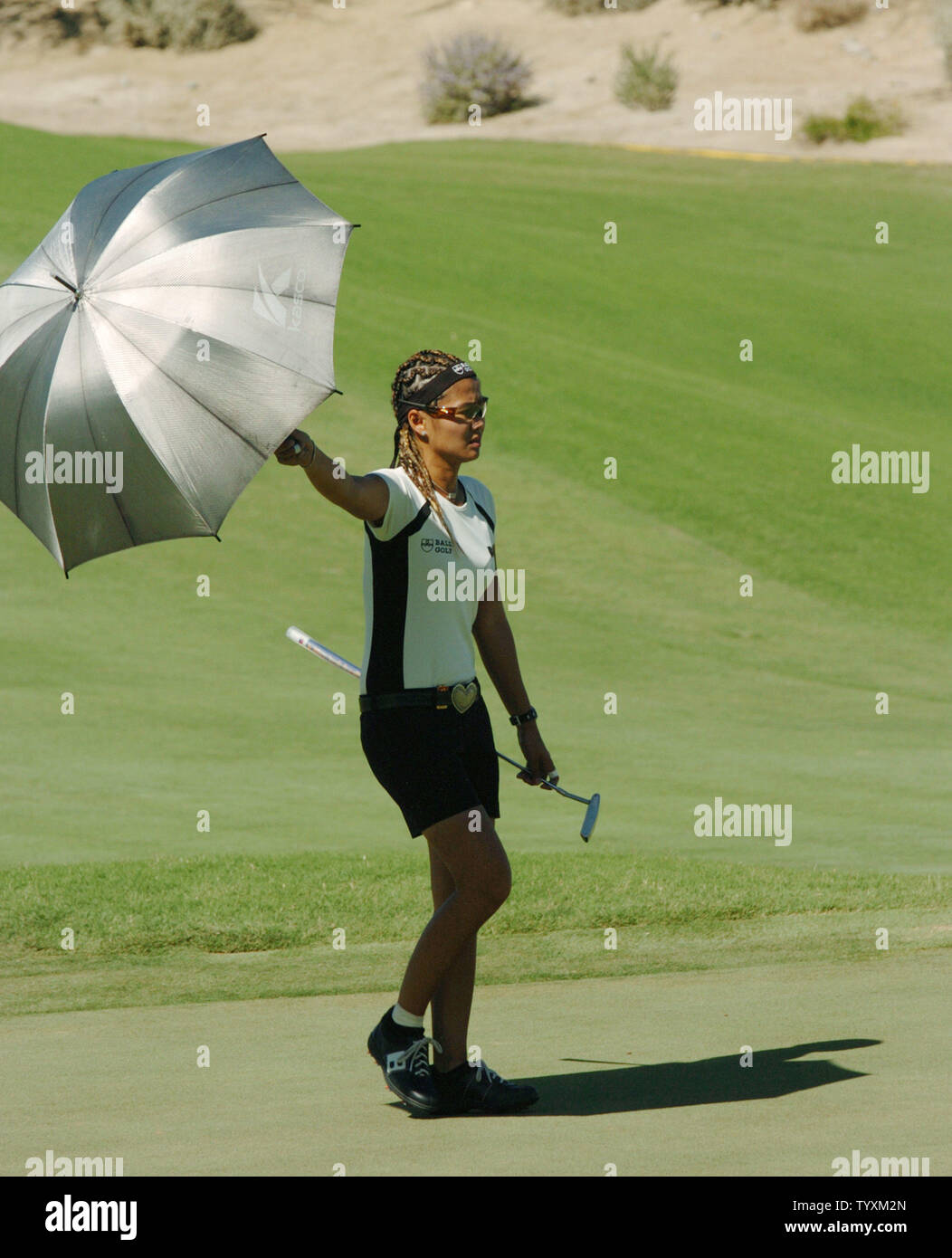 Jennifer Rosales walks to the 18th green with an umbrella to beat the ...
