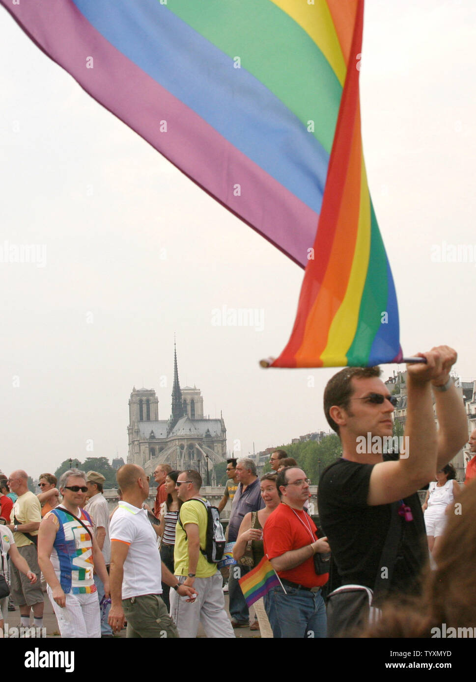 A parade participant waves a flag as he passes Notre Dame Cathedral en ...