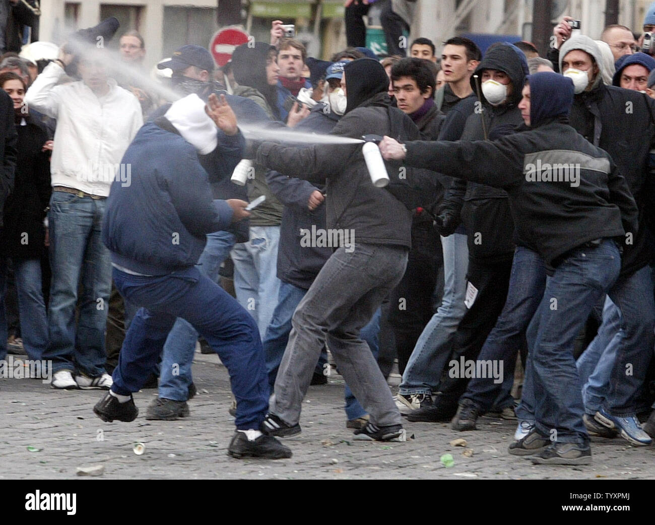 Plainclothes policemen spray tear-gas onto a rioter after a mass ...