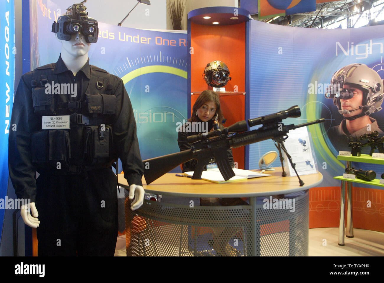 An exhibitor sits behind her stand displaying Israeli-made an aviator's ...