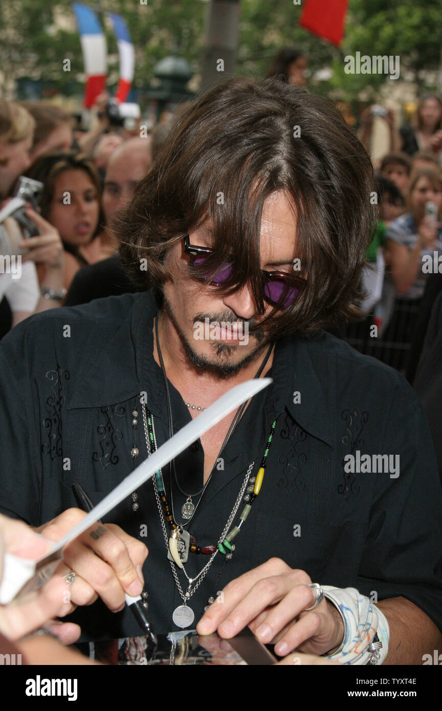 Actor Johnny Depp signs autographs on the red carpet for the premiere ...
