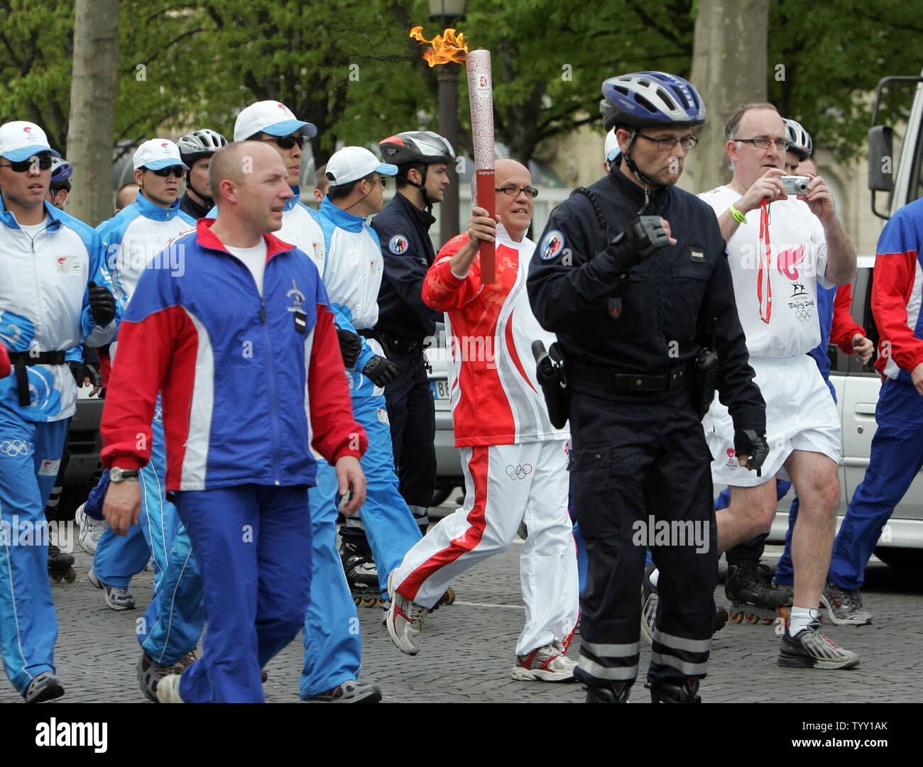 French security forces surround an athlete carrying the Olympic torch ...