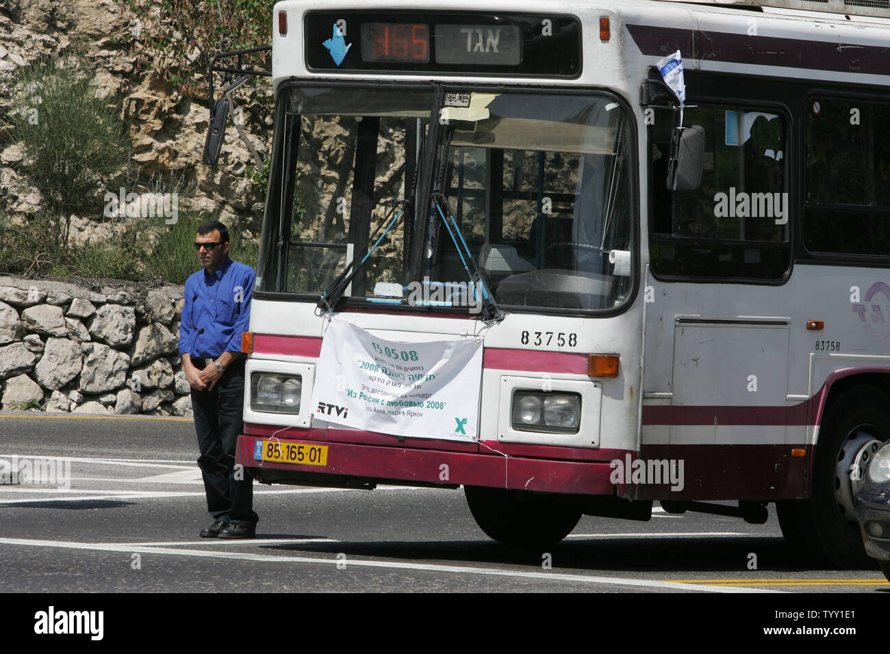 An Israeli bus driver stands next to his bus as a siren wails in memory ...