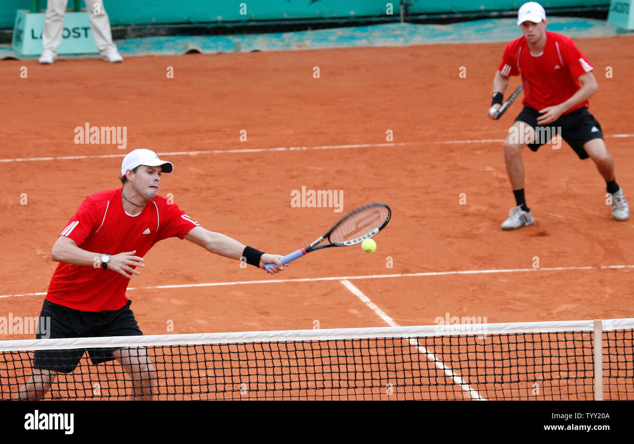 American Bob Bryan (L) hits a volley while his brother Mike approaches ...