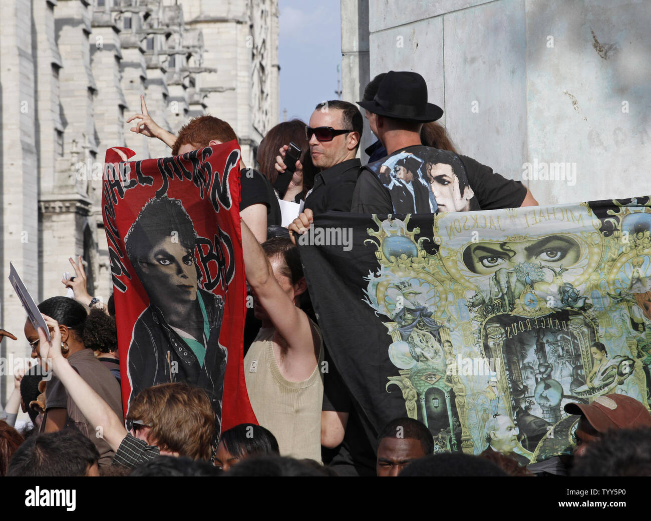 Fans carry signs honoring deceased singer Michael Jackson at a ...