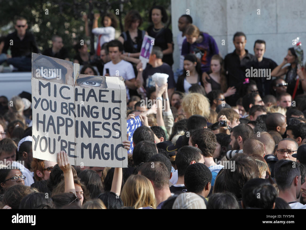 A fan carries a sign honoring deceased singer Michael Jackson at a ...