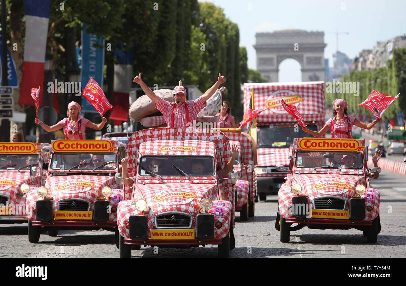 A caravan rides along the Avenue des Champs-Elysees before the final ...