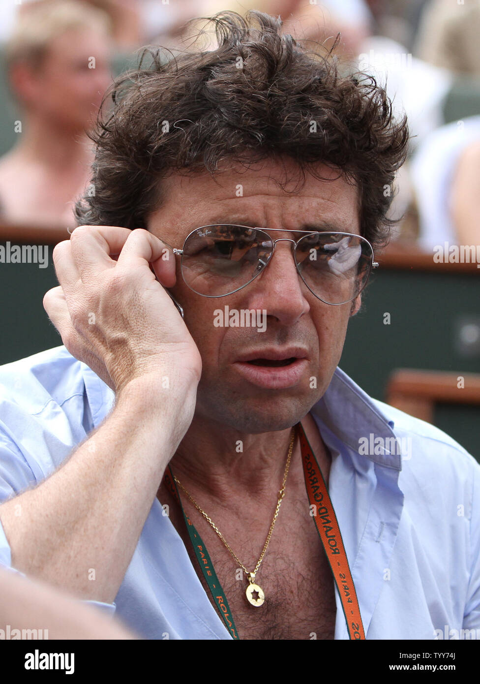 French singer/actor Patrick Bruel talks on his phone while watching the ...