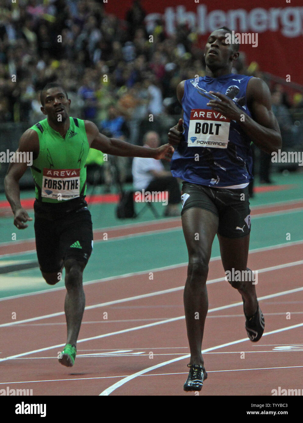 Usain Bolt (R) crosses the finish line ahead of Mario Forsythe to win ...