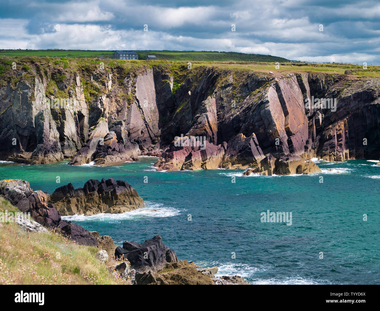 Tilted strata of red sandstone sedimentary bedrock cliffs from the ...