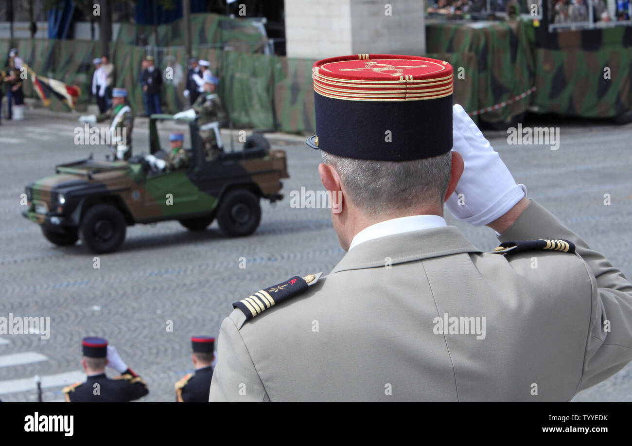A French military officer salutes the passing soldiers during the ...