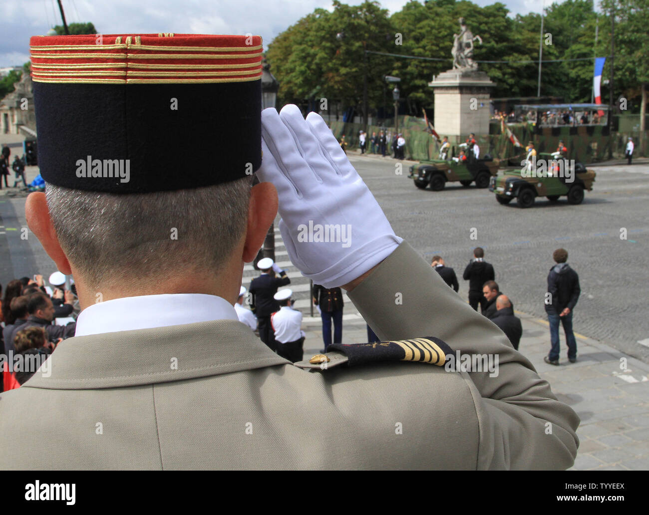 A French military officer salutes the passing soldiers during the ...