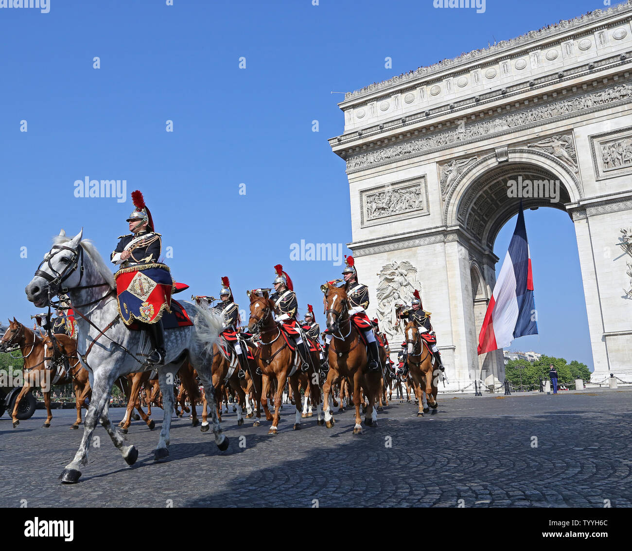 French soldiers on horseback pass in front of the Arc de Triomphe ...