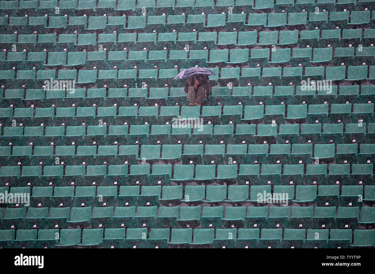 A lone fan watches rain fall on court Philippe Chatrier at Roland ...