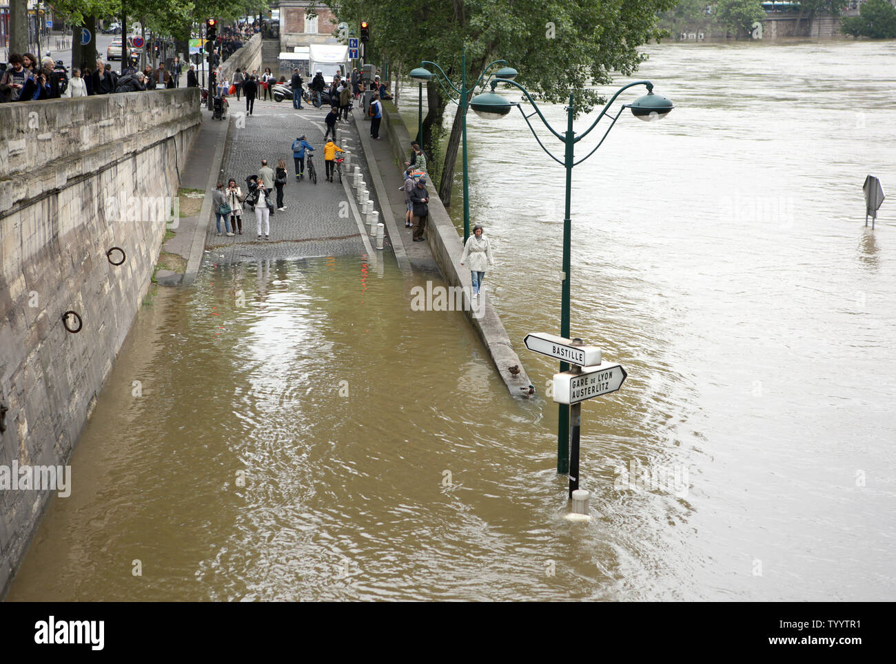 Onlookers check the waters of the Seine river after it overflowed its ...