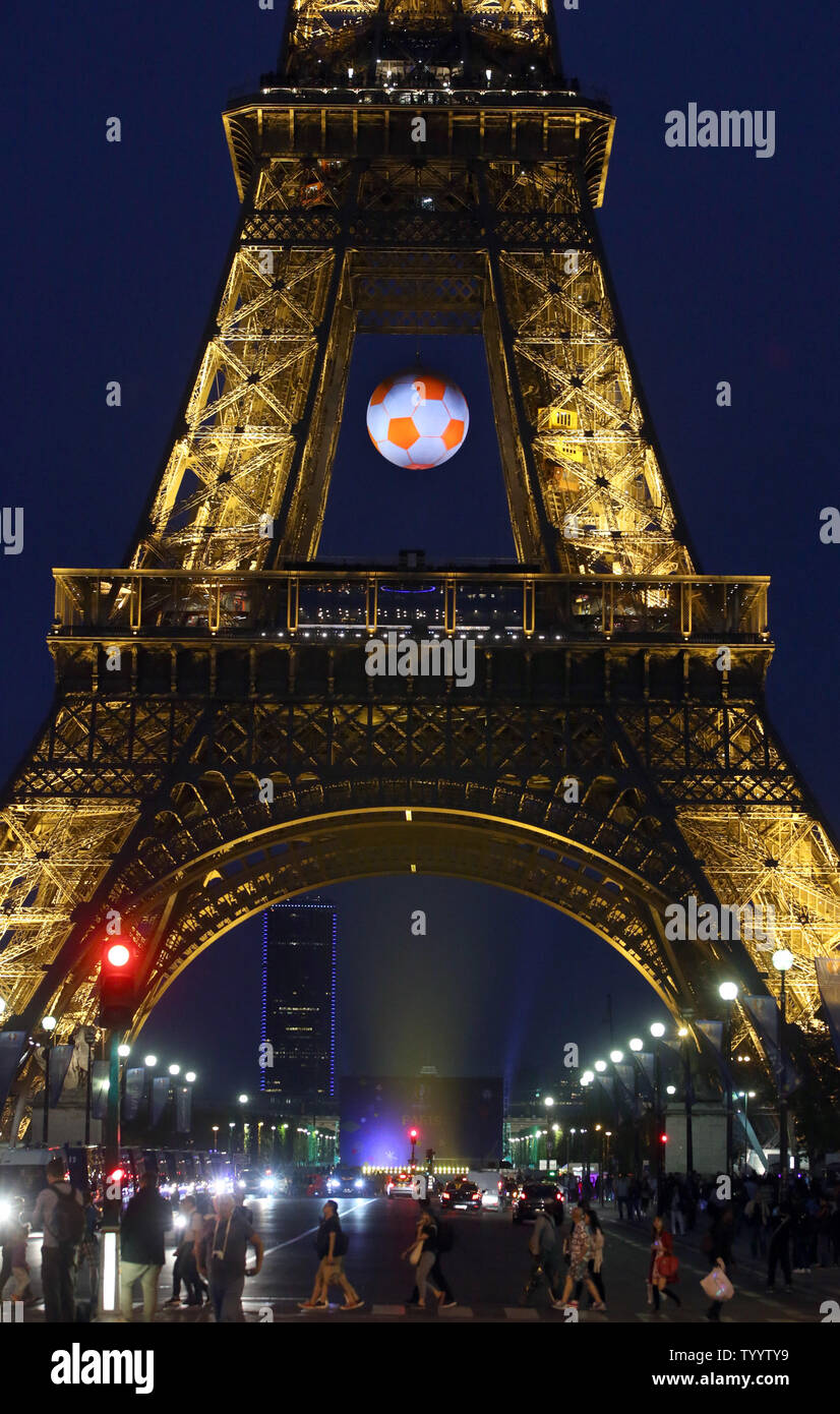 A giant soccer ball hangs from the Eiffel Tower in Paris 11 June 2016 ...