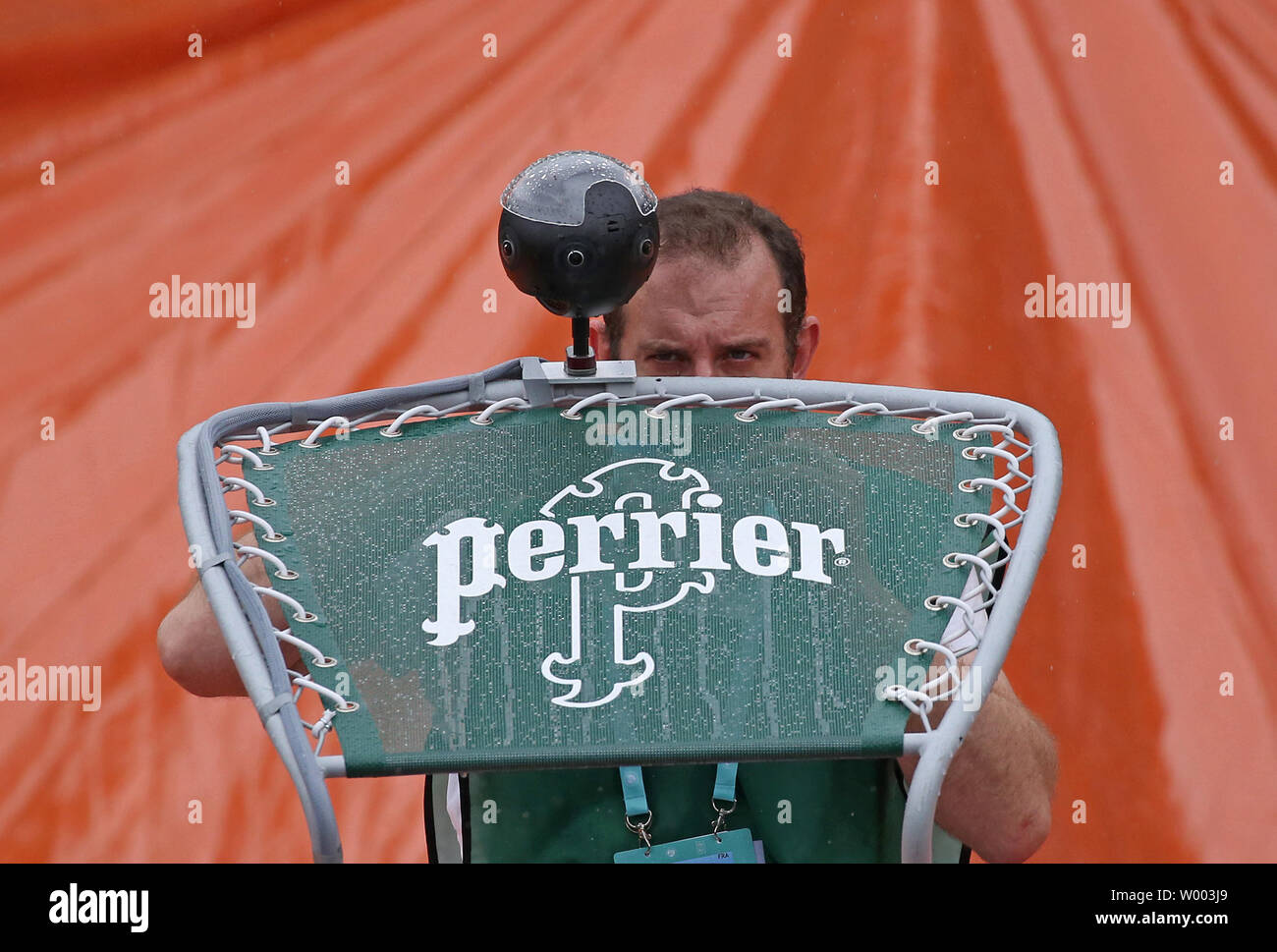 A worker removes the on-court camera from the umpires chair during a ...