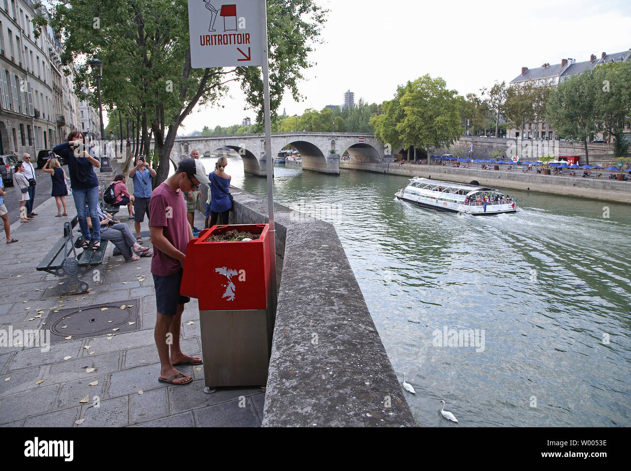 A man stands in front of a new, open-air urinal on Ile Saint-Louis in ...
