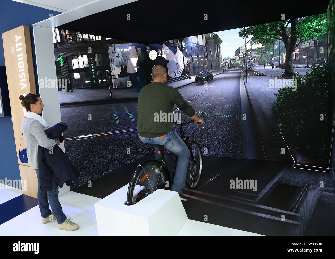 A show attendee pedals on a 3D bicycle simulator during press day at ...