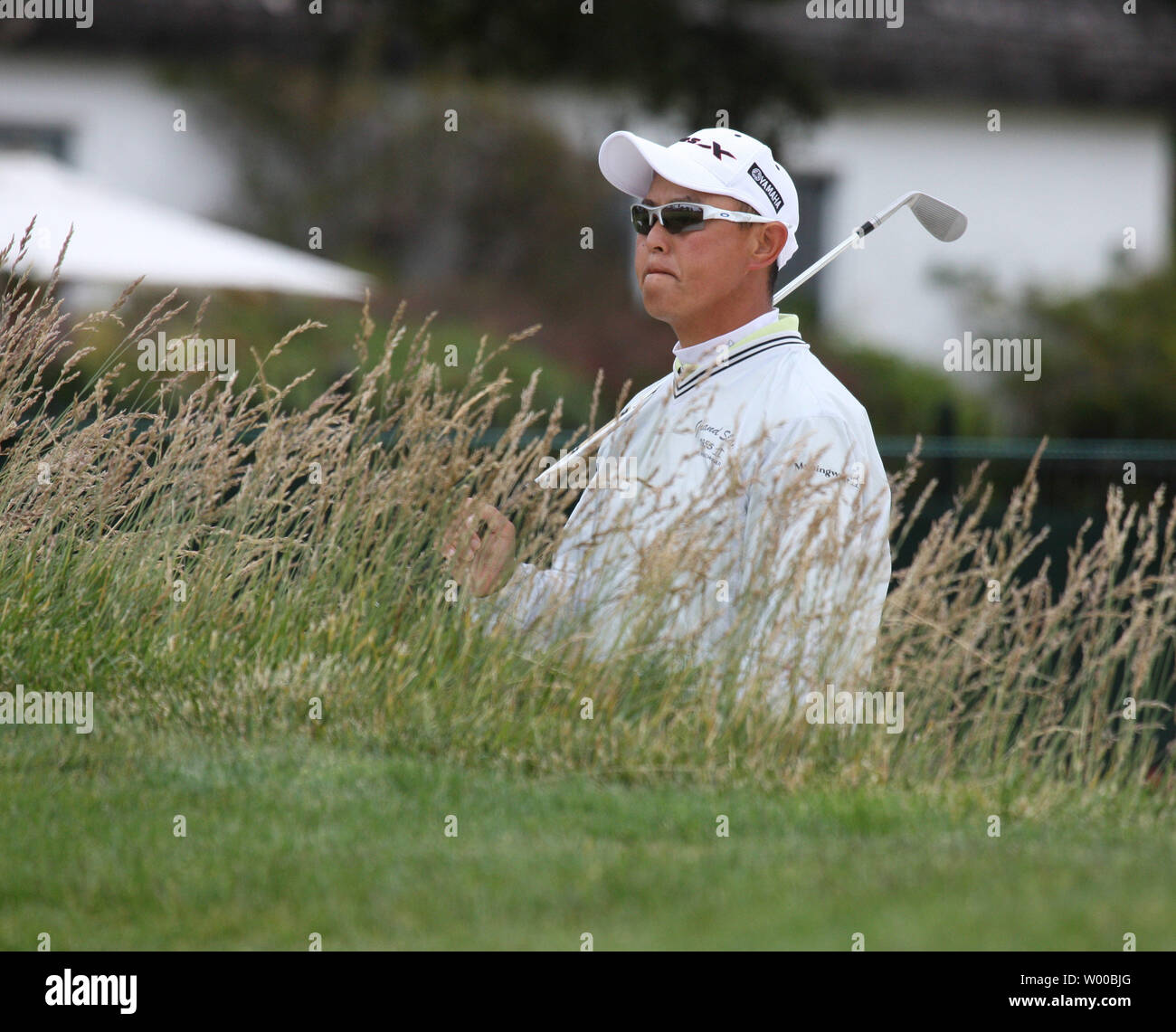 Toru Taniguchi of Japan surveys the green from a bunker on the 12th ...