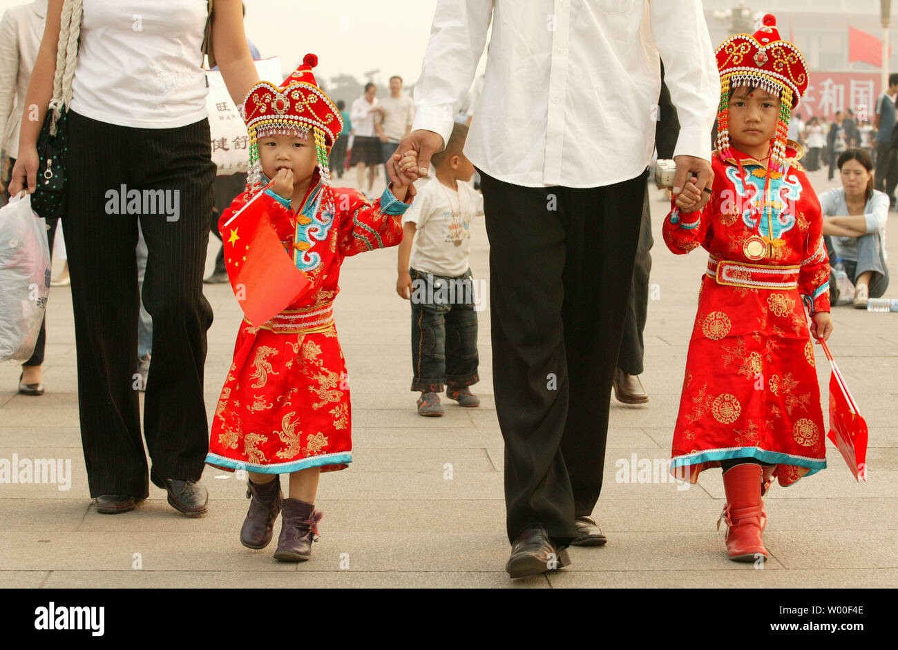 Young Chinese children dressed in traditional costumes walk with their ...