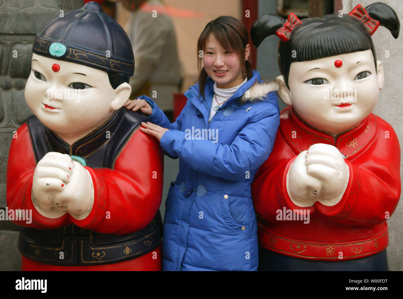 A Chinese woman poses with traditional, good luck statues placed in ...