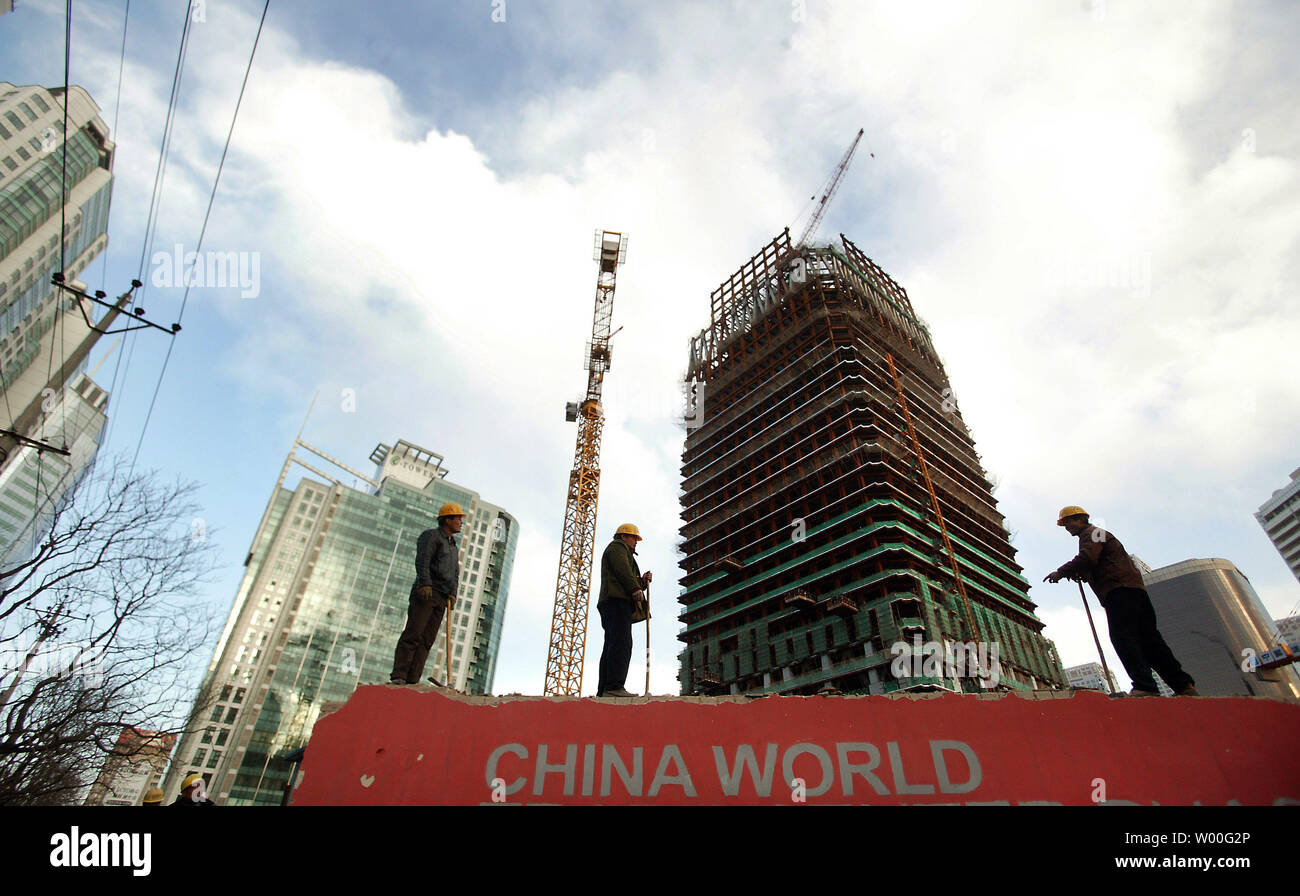 Construction workers take down a brick wall in front of Beijing's soon ...