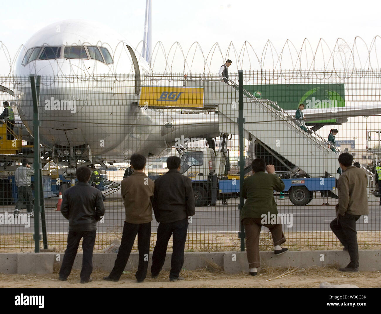 A group of men look at a Chinese airliner at Beijing's international ...