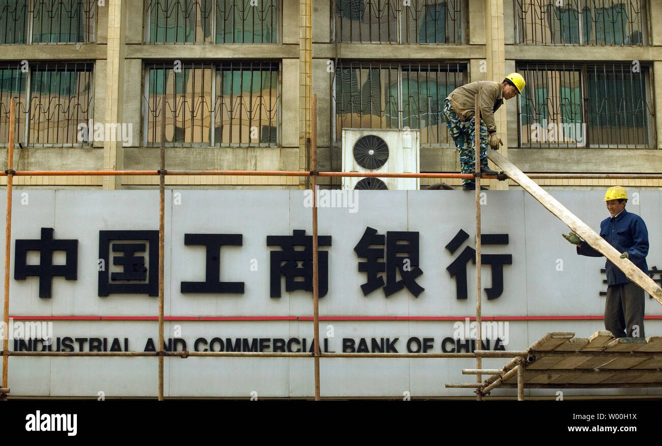 Chinese construction workers assemble scaffolding on the front facade ...