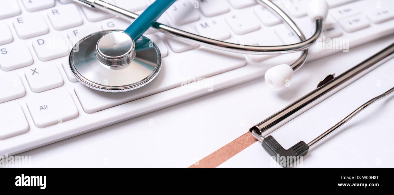 Blue stethoscope on computer keyboard on white table background. Online ...