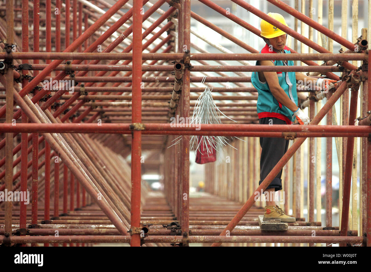 Chinese construction workers stands on scaffolding erected to build an ...