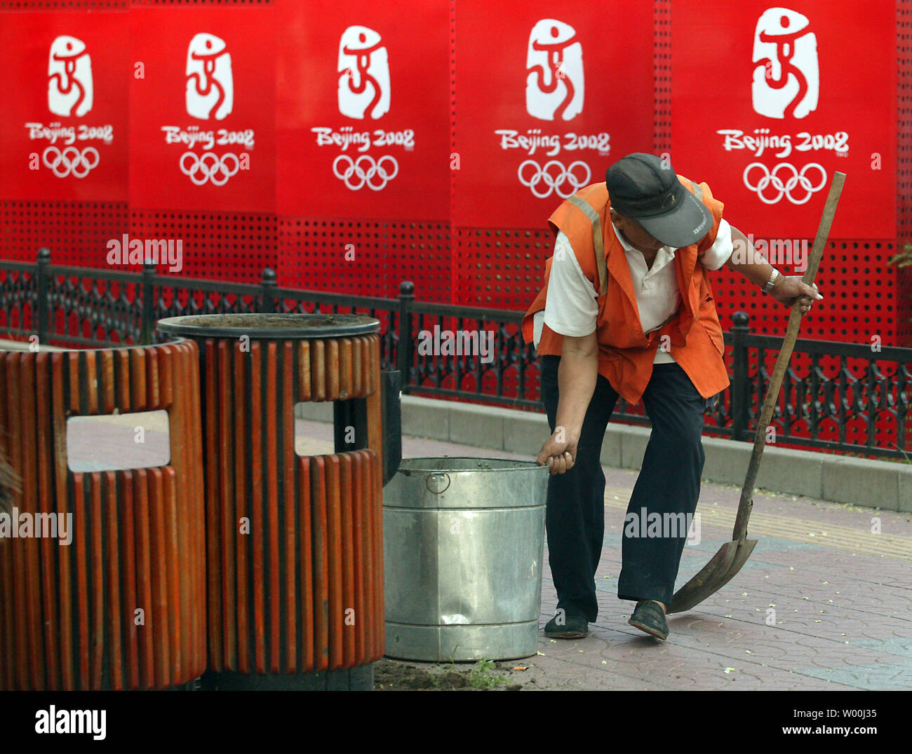 A city worker empties public trash cans near signs promoting the fast ...