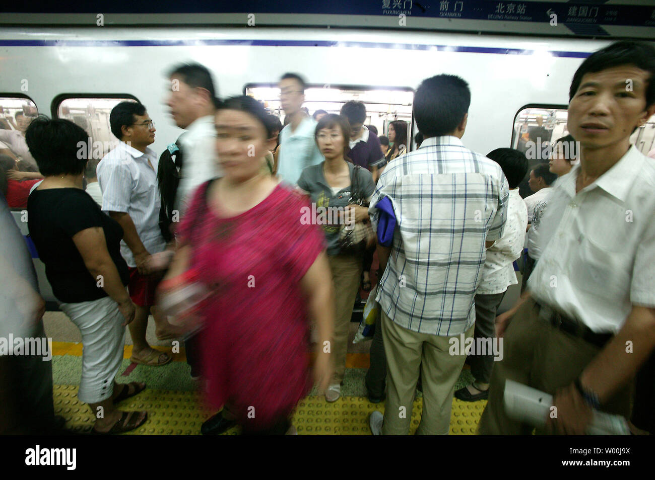 Chinese commuters exit their train, just weeks before the start of the ...