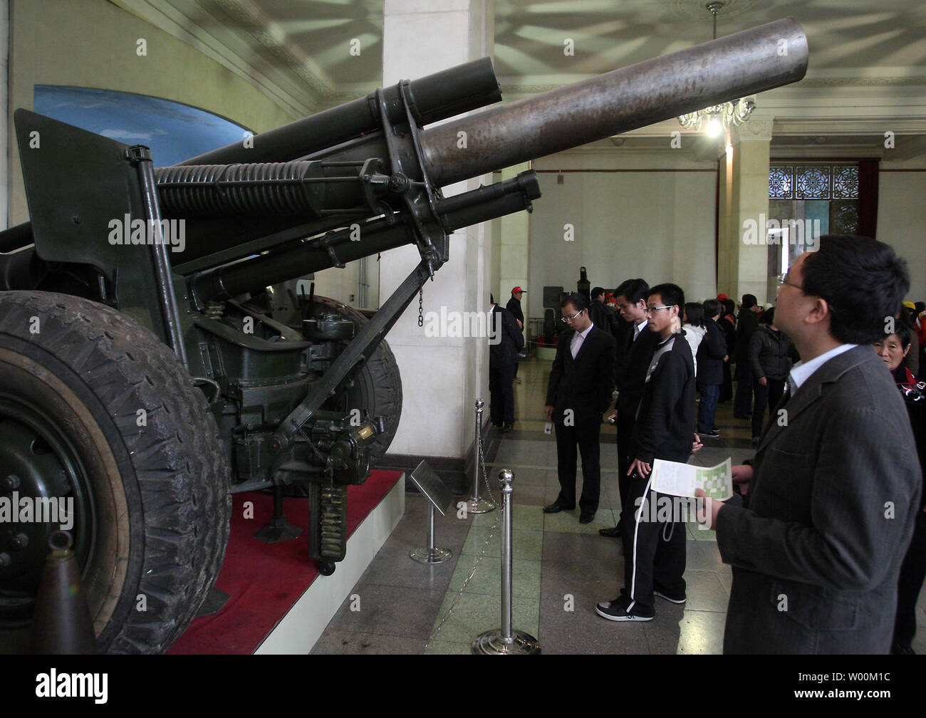 Chinese tourists inspect an old U.S. Howitzer, captured during the ...
