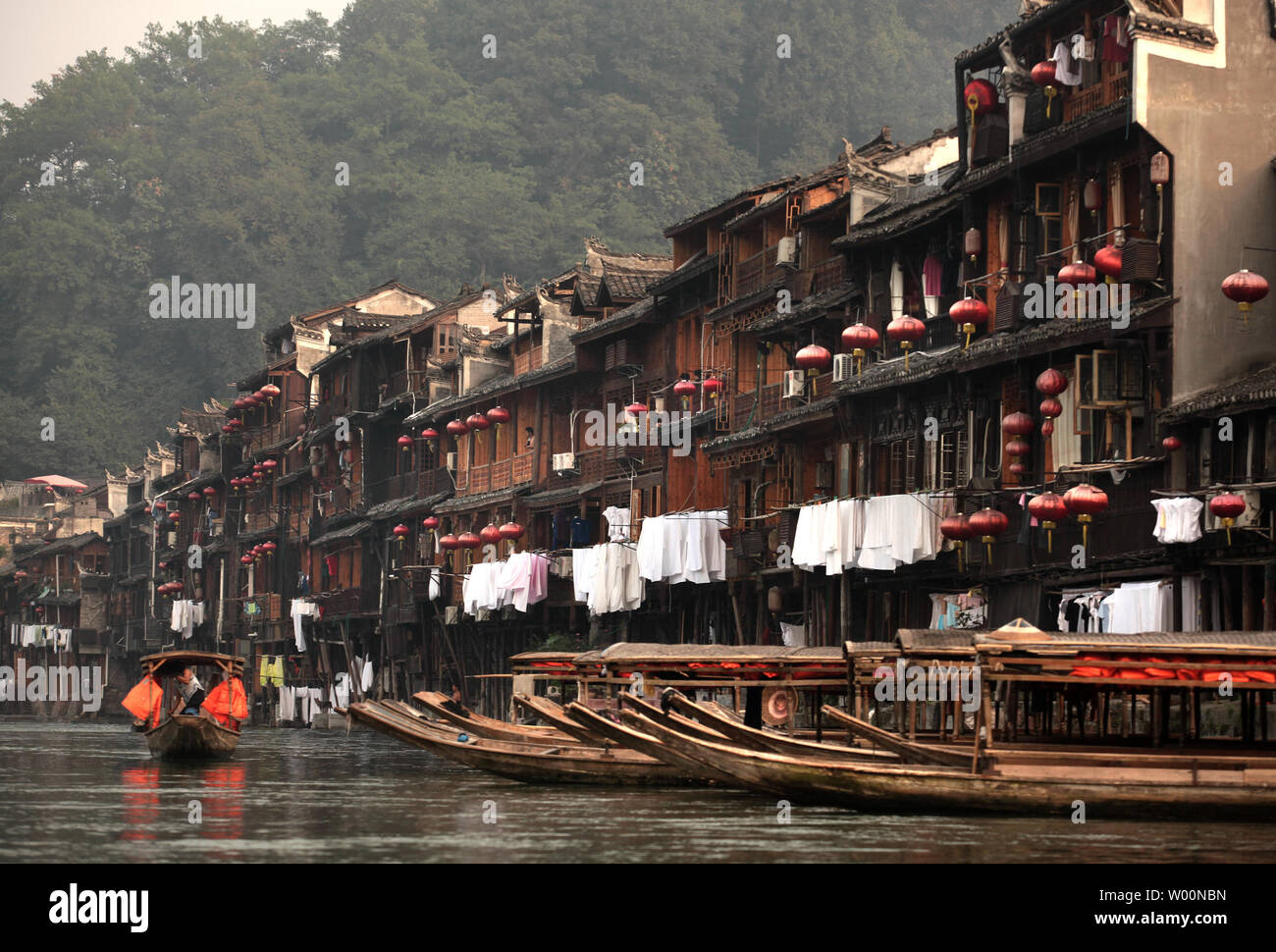 A Chinese boatman, hoping to give tourists a ride, makes his way up ...
