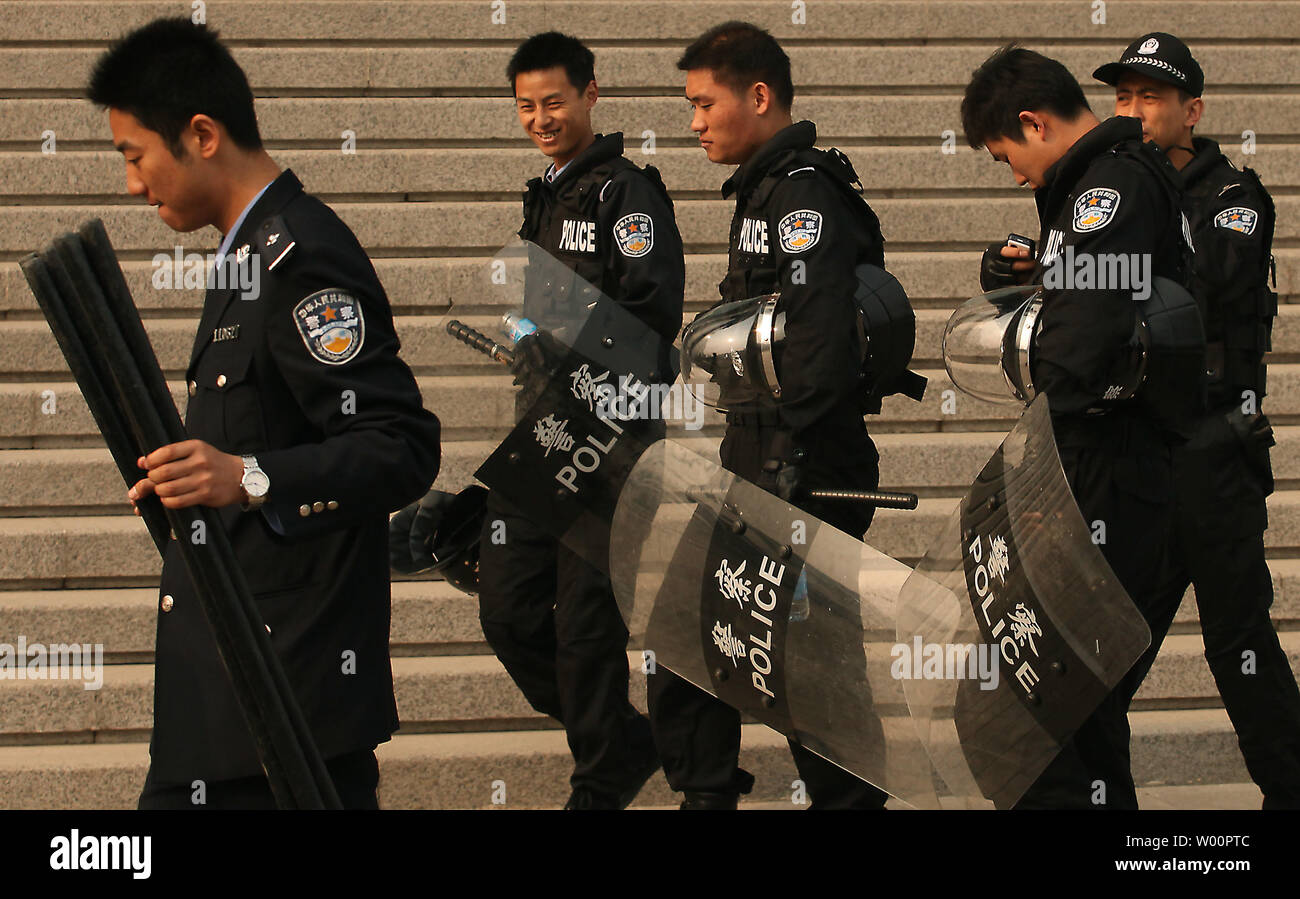 Chinese police with riot gear walk down a street in Beijing on April 19 ...
