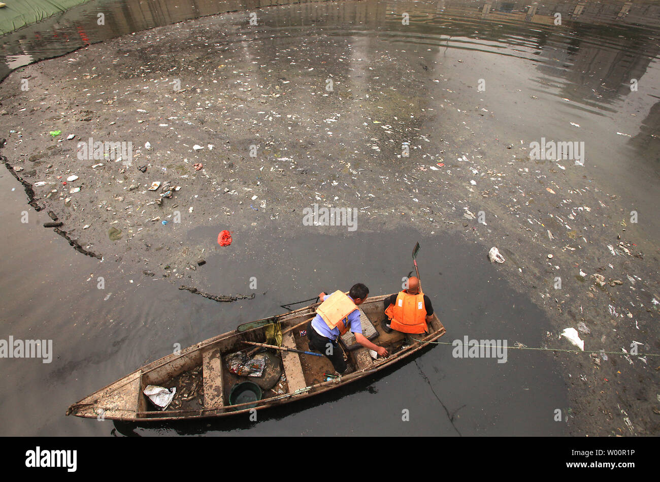 Chinese workers clean a heavily-polluted canal running through central ...