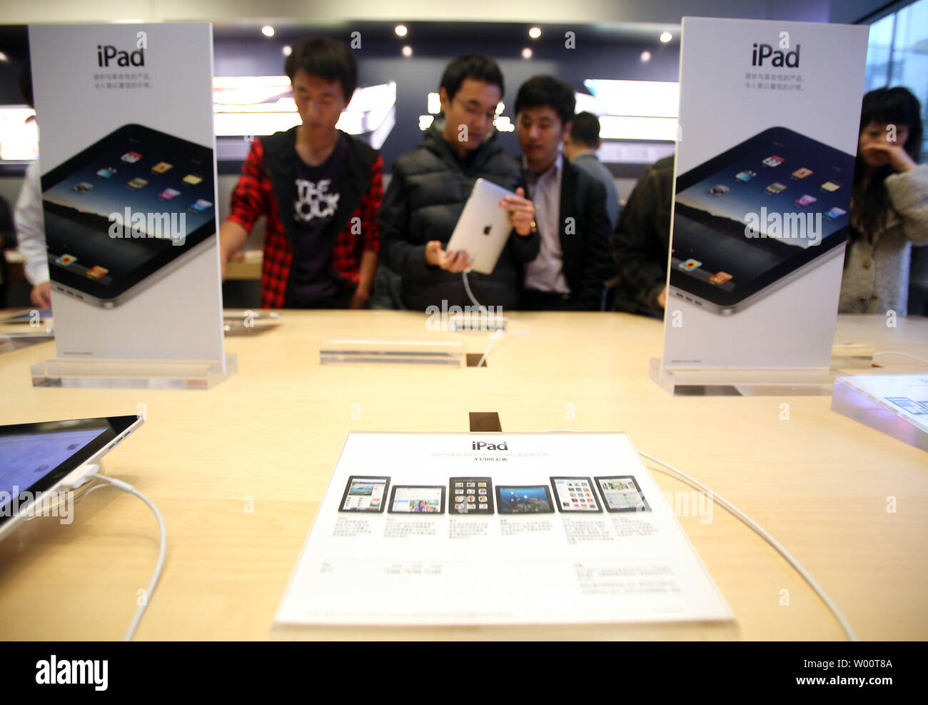 Chinese shoppers check out iPads on display at Apple's flagship store ...