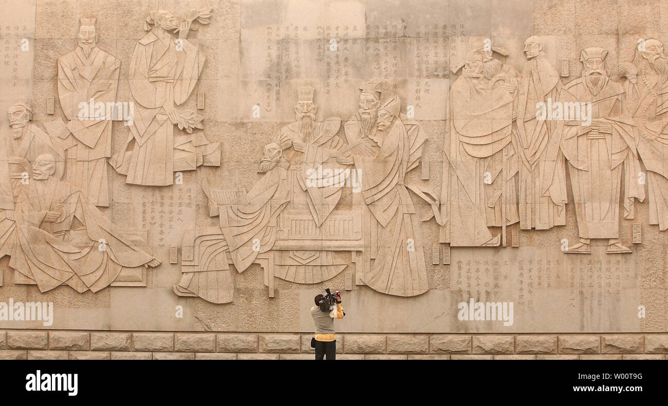 A Chinese cameraman films the Cultural Wall of Ancient Medicine, which ...